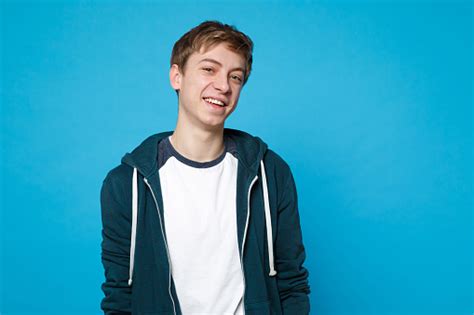 스튜디오에서 파란색 벽 배경에 고립 된 캐주얼 복장에서 쾌활 한 즐거운 젊은 남자 웃는 초상화 사람들은 진심으로 감정 라이프 스타일 개념입니다 복사 공간을 모의 합니다 광고