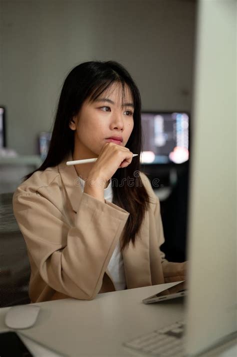 Young Concentrated Asian Businesswoman Is Working In The Office Looking At Her Computer Screen