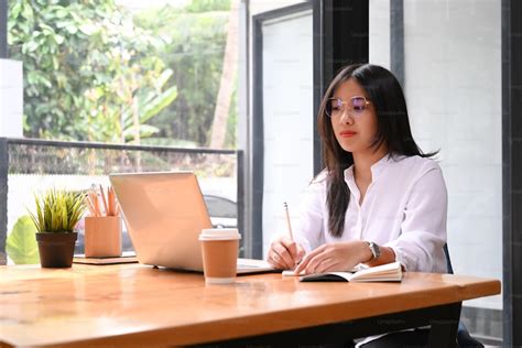 커피숍에 앉아 노트북 컴퓨터로 작업하는 젊은 여성 기업가 사진 Unsplash의 태국 이미지