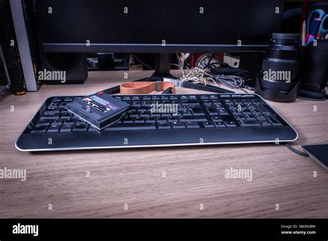 Vintage Data Cartridge Resting On Contemporary Keyboard Highlighting Technological Progression