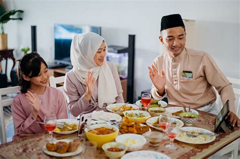 하리 라야 에딜피트리 축하를 위해 친구와 가족을 부르는 전통 의류 영상에 있는 말레이 무슬림 가족 가족에 대한 스톡 사진 및 기타 이미지 Istock