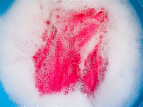 Top View Of Washing Red Shirt With Detergent Powder Bubble Foam In Tub
