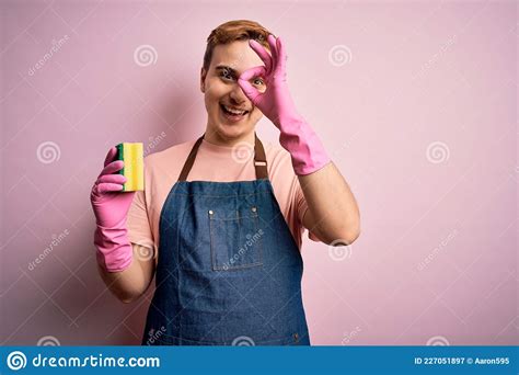 Handsome Redhead Man Doing Housework Wearing Apron And Gloves Using