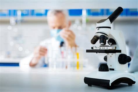 내 악기 화학 실험을 하고 배경으로 직장에 앉아 있는 동안 머리를 숙이는 세심한 과학자의 실루엣 사진 Unsplash의