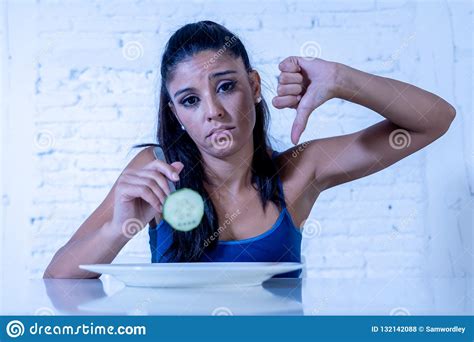 Καταθλιπτική κάνοντας δίαιτα γυναίκα που κρατά τη λαϊκή εξέταση το μικρό πράσινο λαχανικό στο