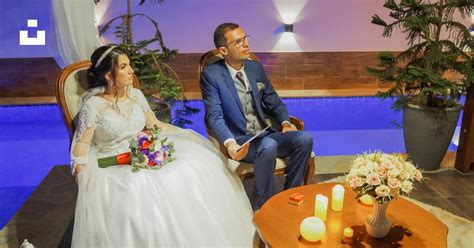 하얀 웨딩 드레스를 입은 여자 옆에 앉아 있는 파란색 양복 재킷을 입은 남자 사진 Unsplash의 무료 결혼식 이미지