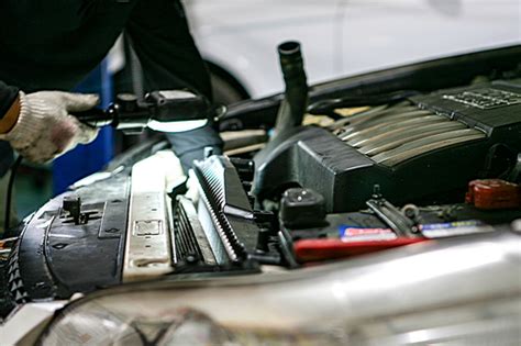 유토이미지 카센터에서 자동차 정비기술자의 자동차 점검 근접 확대 모습 자동차 유지보수 정비 점검