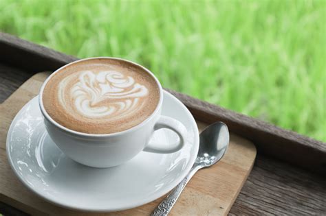 하트 모양의 커피 컵 라떼 아트와 나무 테이블에 다크 커피와 다크 초콜릿 직장이나 주말 회의 후 커피 휴식을위한 거품 음료 다크