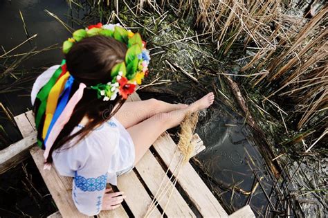 Украинская девушка в рубашке и венке цветка на его голове на B Стоковое Изображение