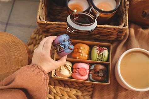 그녀의 손에 마카롱을 들고 아늑한 가정 분위기에서 배경에 모듬 마카롱 상자를 들고 있는 소녀 가꿔주기에 대한 스톡 사진 및 기타 이미지 Istock