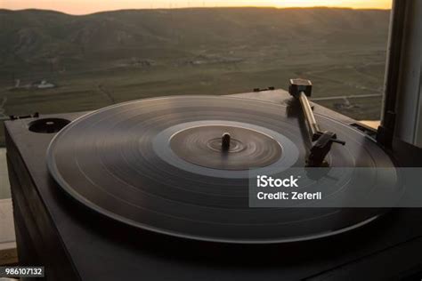 턴테이블 비닐 레코드 플레이어 산에 일몰의 배경에서 Dj 믹스 음악 재생을 위한 소리 기술 검은 비닐 레코드입니다 빈티지 비닐 레코드 플레이어입니다 개념과 주제에 대한 스톡