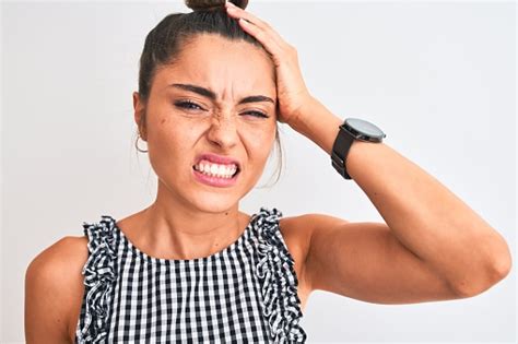 고립 된 흰색 배경 위에 서있는 캐주얼 드레스를 입은 젊은 아름다운 여성은 부끄러움과 깜짝 얼굴에 충격을 받고 화가 나서 좌절했습니다 실수에 대한 두려움과 화가 갈색 머리에