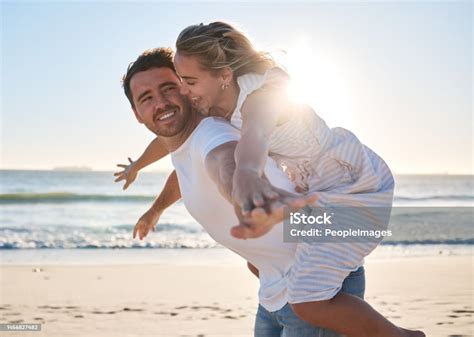 행복 커플 피기백은 야외에서 함께 사랑 여행 또는 여름 휴가를 위해 해변을 산책합니다 남자 등을 들고 여자를 미소로 안고 장난스럽고 즐거운 시간을 즐기고 바닷가를 걷고 있다