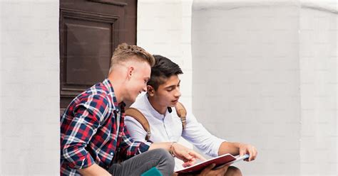 대학 앞 돌계단에 앉아 있는 두 명의 잘생긴 십대 학생 사진 Unsplash의 고등학교 이미지