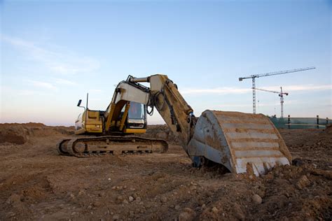 굴삭기는 도로 공사에 건설 현장에서 작업 백호는 기초를 위한 땅을 파고 하수도 라인을 포장합니다 화물의 굴착 적재 리프팅 및 운반을 위한 건설 기계 0명에 대한 스톡 사진
