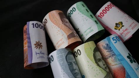 Premium Photo Rolled Indonesian Rupiah Or IDR Banknotes On The Black Background Various