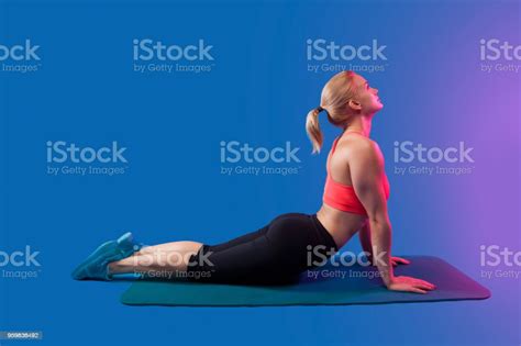 금발 여자는 파란색 바탕에 블루 요가 매트에 기지개에 종사 텍스트를 위한 공간 가냘픈에 대한 스톡 사진 및 기타 이미지 가냘픈 거리 건강한 생활방식 Istock