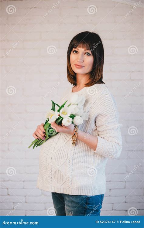 Молодая красивая беременная женщина с белыми тюльпанами Стоковое Изображение изображение