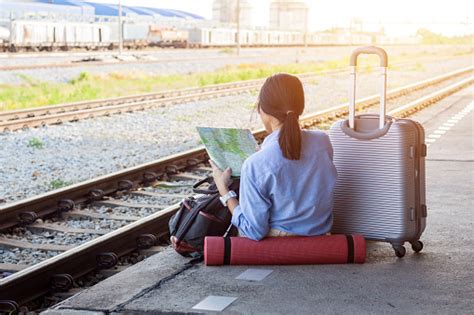 기차역 및 여행 계획에 대 한 지도에 보이는 젊은 여자 배낭 배낭 젊은 여행자 여자는 우울 하 고 기차를 기다리는 동안 강조 했다 가방에 대한 스톡 사진 및 기타 이미지