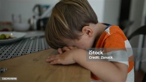 수줍은 아이 커버 얼굴 와 손 어린 소년 앉아 에 앉아 테이블 느낌 보어 아이에 대한 스톡 사진 및 기타 이미지 아이 두통 소년 Istock