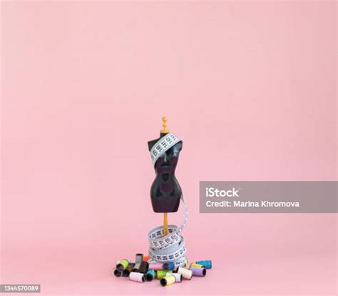 분홍색 배경의 축소된 마네킹과 스풀의 측정 및 여러 가지 색상의 실을 위한 테이프 직물에 대한 스톡 사진 및 기타 이미지 직물 재단사 공예 Istock