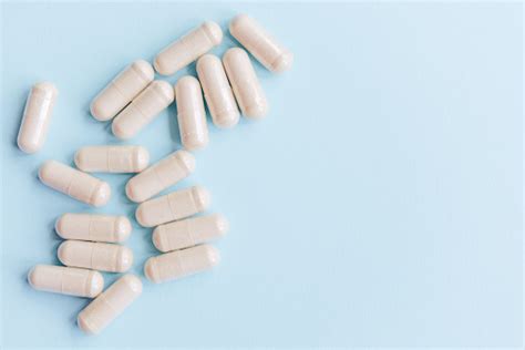 파란색 테이블에 흰색 알약 의료 약국 및 의료 개념 공간을 복사합니다 텍스트 또는 로고를위한 공간 광고 또는 기타 아이디어로 특별 제안을위한 모형 0명에 대한 스톡 사진 및