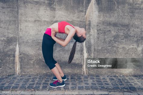 젊은 유행 Sportswoman 여름 날에는 거리에 스트레칭입니다 그녀는 매우 인형 하 고 유연한 좋은 요가 위치 하 고 유행 스포츠 옷 신발 입고 가냘픈에 대한 스톡 사진