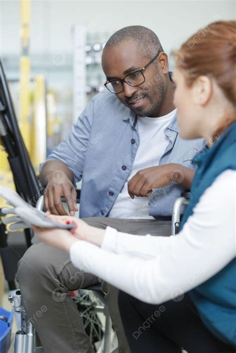Woman Assisting Man In Wheelchair In Hardware Store Photo Background