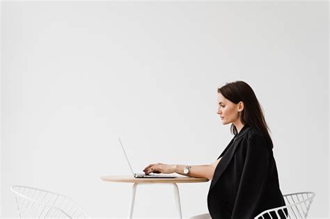 노트북을 가진 집중 영어 교사는 비디오 통신을 통해 온라인 수업을합니다 원격 교육 매력적인 소녀는 흰색 배경에 노트북에서 타이핑하고 채팅합니다 25 29세에 대한 스톡 사진