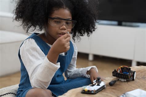 집에서 프로젝트 장난감 로봇 기술을 배우고 구축하는 여학생 교실에서 아프리카 계 미국인 어린이 소녀 훈련 및 제어 장난감 로봇