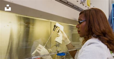 흰색 실험실 코트와 장갑을 낀 여자가 기계에서 일하고 있다 사진 Unsplash의 무료 암 이미지