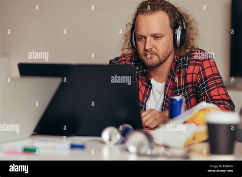 Man Busy Coding On Laptop Male Computer Programmer Wearing Headphones Working On Laptop At Tech
