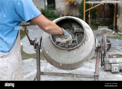 Labore Worker Operating Concrete Cement Mixer At Construction Site