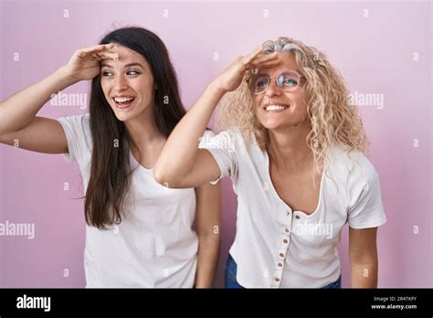 Mother And Daughter Standing Together Over Pink Background Very Happy