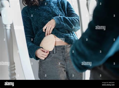 A Female Colon Cancer Survivor Looks At Her Bag In A Mirror Confidence