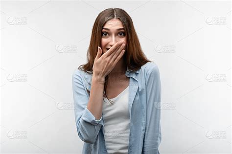 有魅力的白人女孩长栗色头发穿着休闲衣服咯咯笑用她的手盖住她的嘴人的情绪表情概念