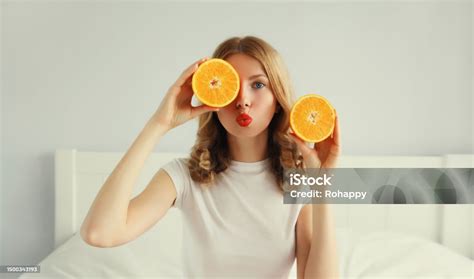 여름 영양 다이어트 및 채식 개념 집에 있는 하얀 방에서 오렌지 과일 조각을 들고 있는 행복하고 쾌활한 젊은 여자 30 34세에 대한 스톡 사진 및 기타 이미지 Istock