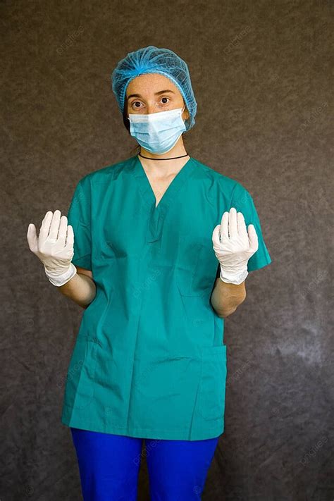 พื้นหลังภาพเหมือนของบุคลากรทางการแพทย์หญิงในชุดทางการแพทย์พร้อมถุงมือหน้ากากและหมวกผ่าตัด รูป
