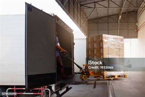 손 팔레트 잭 하역 포장 상자를 사용하여 작업자화물 컨테이너에 배달 트럭 선적 도크 웨어하우스에 적재하는 트럭 공급망 창고 운송 및 물류 트럭에 대한 스톡 사진 및 기타