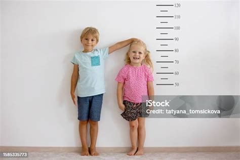 어린 아이들 금발의 소년과 소녀 방 벽에 기대어 높이를 측정하다 2명에 대한 스톡 사진 및 기타 이미지 2명 가득 찬 귀여운 Istock
