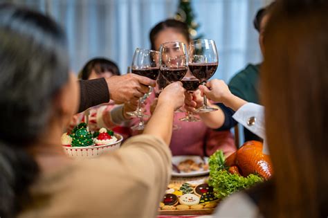 집에서 함께 크리스마스 파티를 축하하는 아시아 사랑스러운 가족 저녁 식사를하는 매력적인 부모와 친척 휴일 추수 감사절 식탁에서 크리스마스 이브를 축하하기 위해 와인 한 잔을