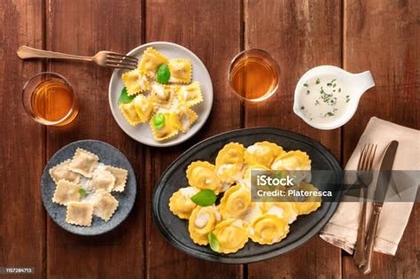 이탈리안 푸드 어두운 소박한 나무 배경에 와인 잔과 화이트 소스와 함께 위에서 촬영 다양한 라비올리의 구색 라비올리에 대한 스톡
