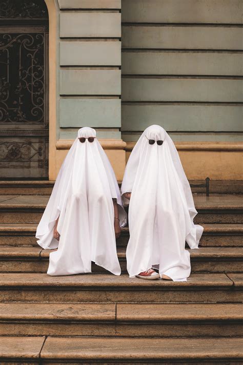 계단에 앉아있는 흰색 유령 의상을 입은 두 사람 사진 Unsplash의 무료 회색 이미지