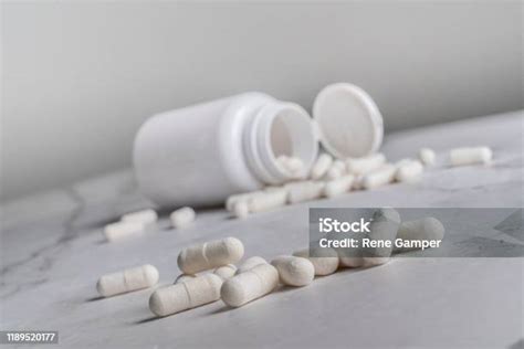 진통제 와 약물 남용 개념 처방약과 알 약 캡슐의 병에 가까이 흰색 대리석 테이블에 떨어지는 개념에 대한 스톡 사진 및 기타 이미지 Istock