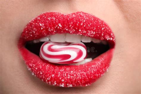 Young Woman With Beautiful Lips Covered In Sugar Eating Candy Closeup