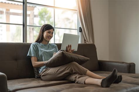 거실에서 편안하게 웃고 있는 여자들 똑똑한 일하는 여성 사람들 노트북입니다 웹 서핑 기술과 연결의 즐거움 게임의 밤 레저 활동에 대한 스톡 사진 및 기타 이미지 Istock