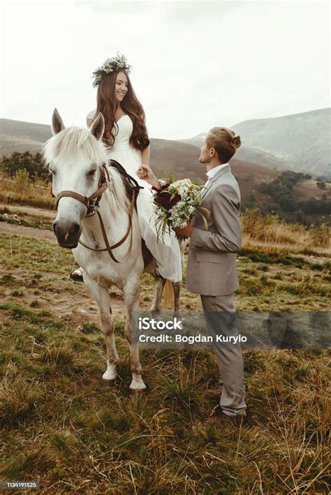 흰색 말과 세련 된 신랑 보호 웨딩 커플 산에서 럭셔리 행사 텍스트 공간을 타고 화려한 신부 결혼식에 대한 스톡 사진 및 기타 이미지 Istock