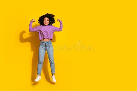 Full Size Photo Of Nice Young Woman Jump Flex Biceps Isolated On Yellow Color Background Stock