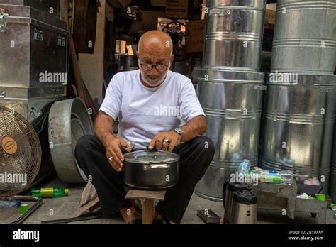 A Bahraini Old Man Repairs Crockery Outside His Shop At The Bab Al