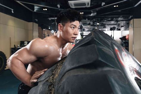 年轻男子在健身房做翻轮胎练习 包图企业站